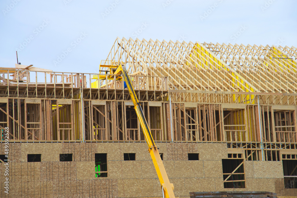 forklift at a construction site of a plywood house wood new frame work ...