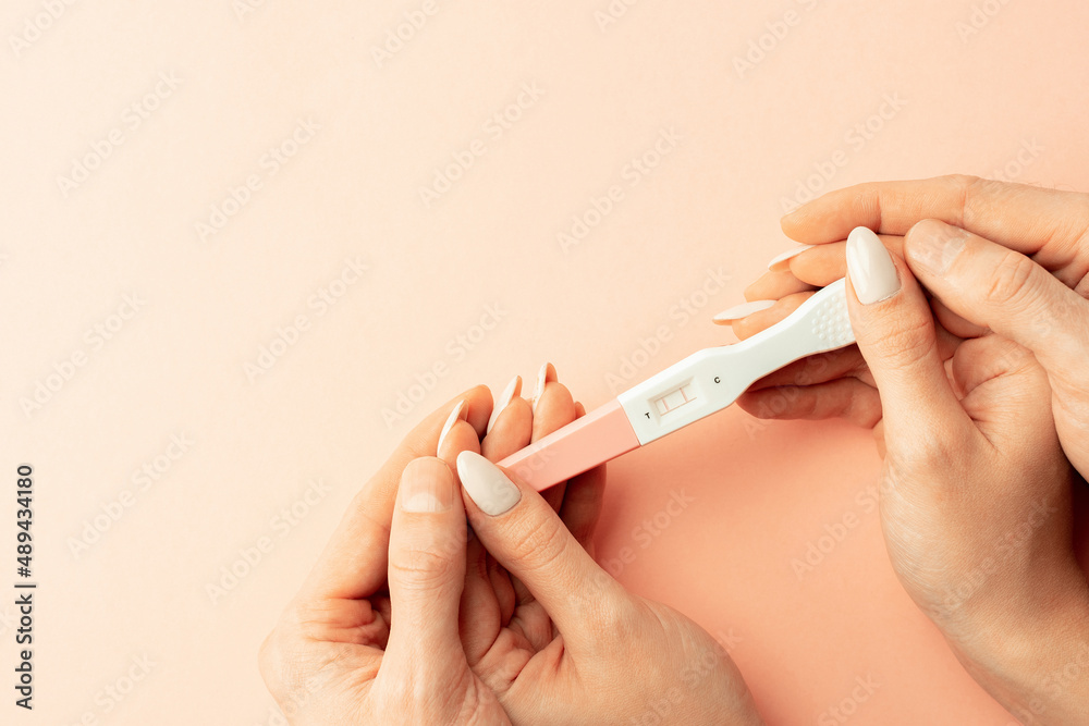 Pregnancy test kit. Female hand hold positive pregnant test with silk ...