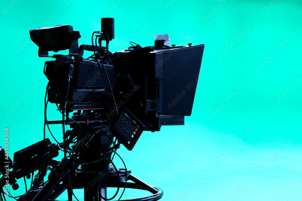 The camera on the tripod, led floodlight, prompter and a monitor on a ...