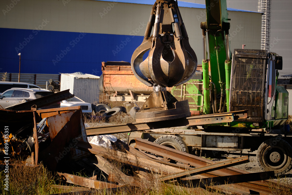 Magnet crane moves scrap metal. Hand of grabber excavator unloading ...