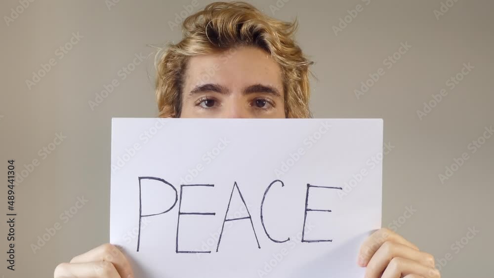 Adult Young Man Holding A Paper Message With The Text Peace, covering ...