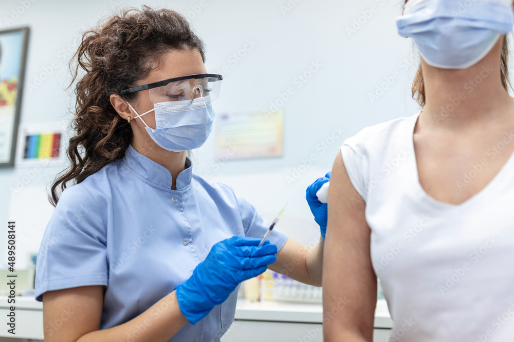 Close up of a Doctor making a vaccination in the shoulder of patient ...