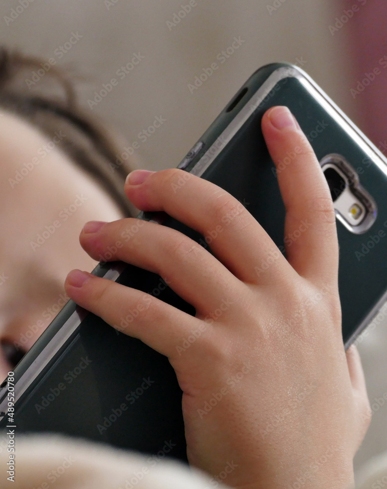 A 4-5 year old child is playing with a smart mobile phone, mobile phone ...