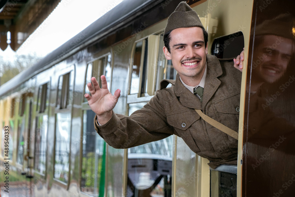 Handsome male British soldier in WW2 vintage uniform at train station ...