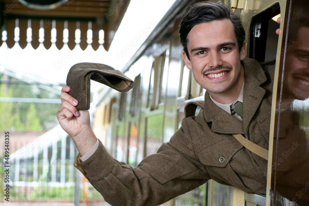 Handsome male British soldier in WW2 vintage uniform at train station ...