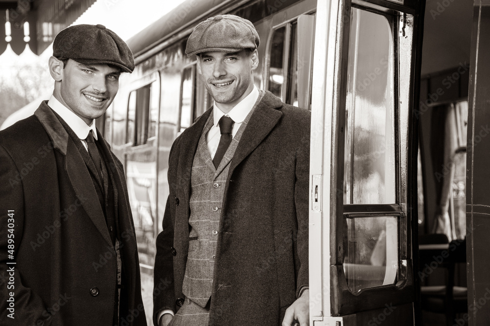Handsome English gangsters standing next to train at railway station ...
