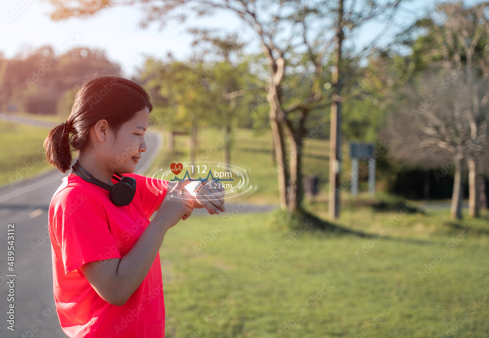 Concept of The technology to check health while exercising.Young woman ...