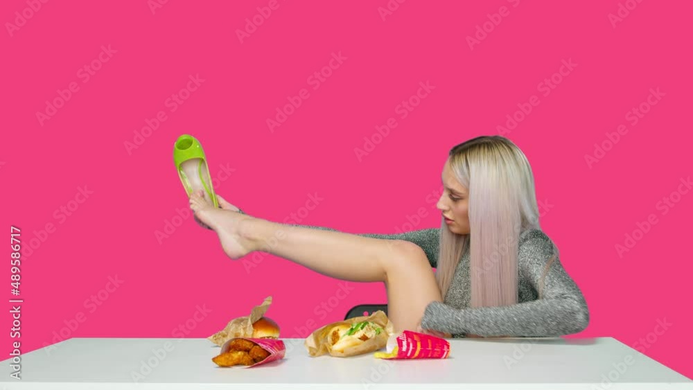 A cute girl sits on a chair, takes off her shoes, puts her feet on the ...