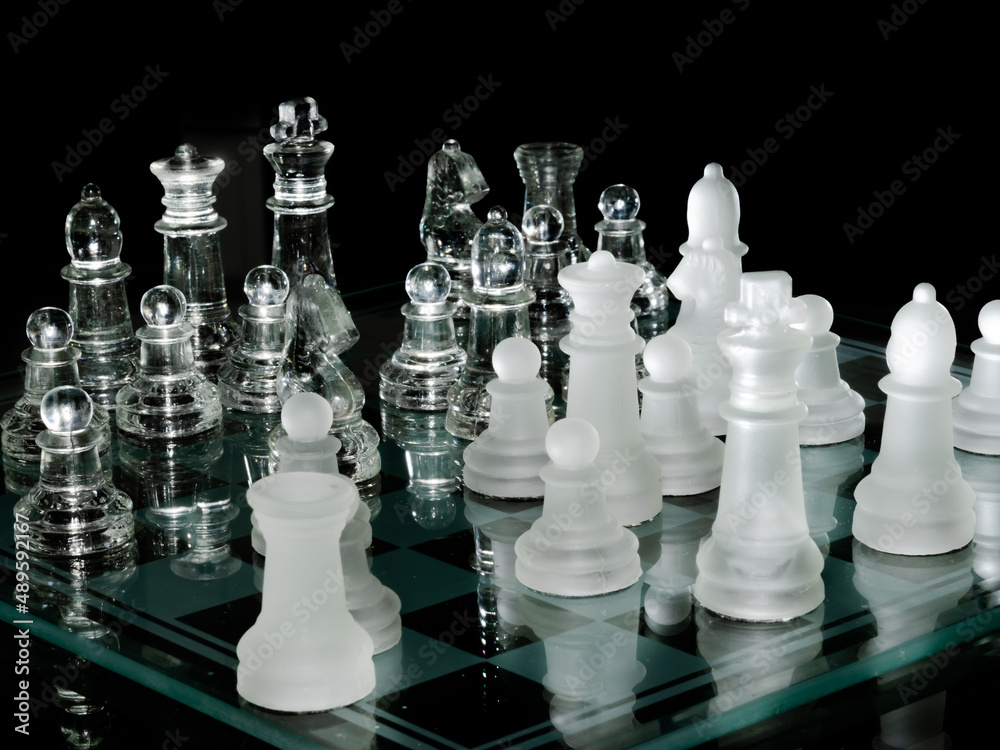 Chess set with glass material pieces and board reflected. White pieces ...