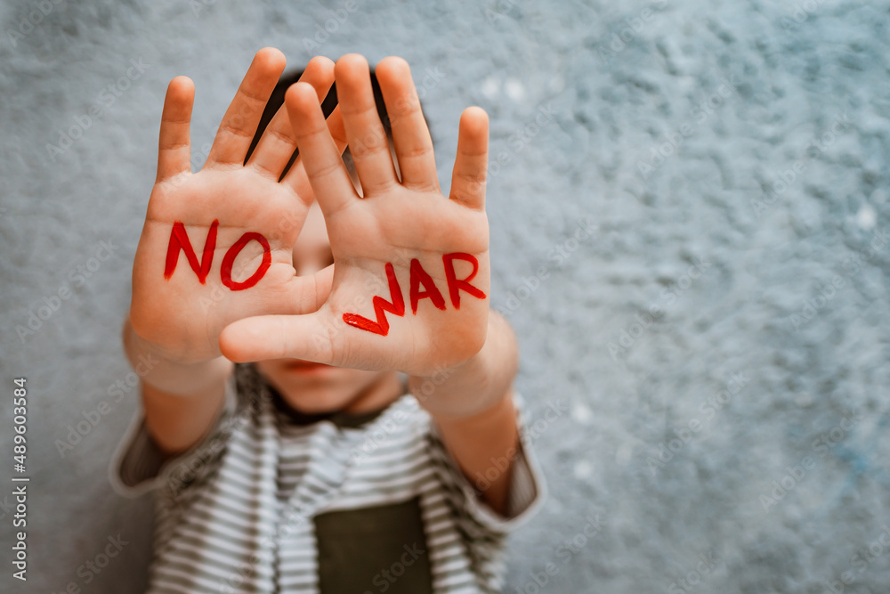 slogan of peace without war is written on the child's hand in red no ...