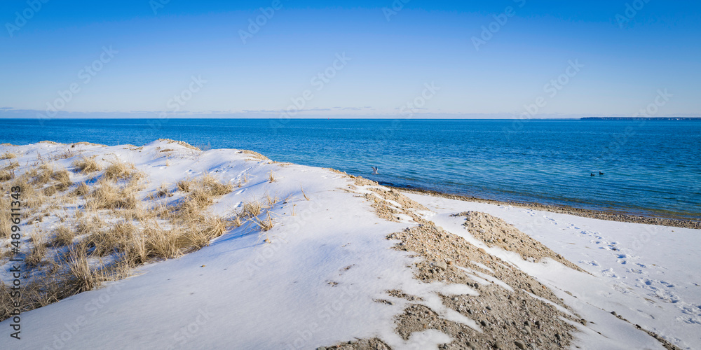 Snow on the beach. Winter seascape over the erosion control sand piles ...