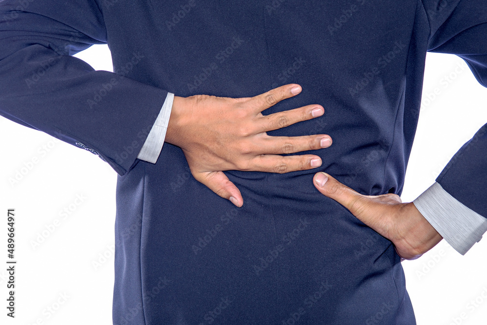 Backache concept bending over in pain with hands holding lower back ...