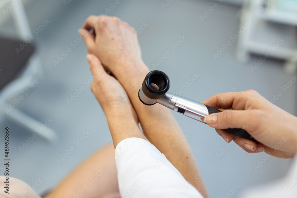 Dermatology. Skilled female dermatologist using a professional ...