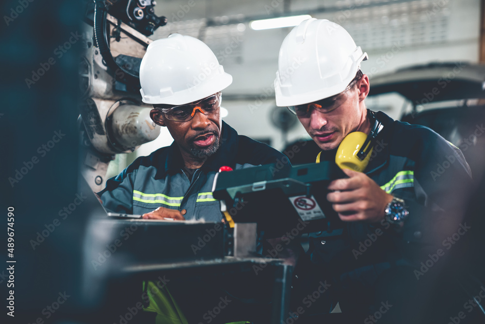 Factory workers working with adept robotic arm in a workshop . Industry ...