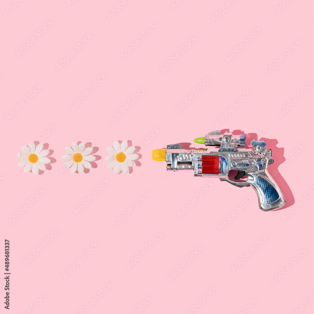 Spring creative layout with space gun and white flowers on pastel pink ...
