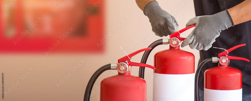 Close up fire extinguisher and firefighter pull safety pin on the ...