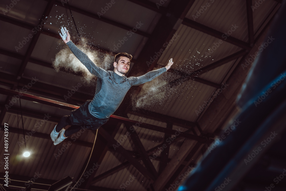 Young man jumping in trampoline inside the sport center. Mid-air Stock ...