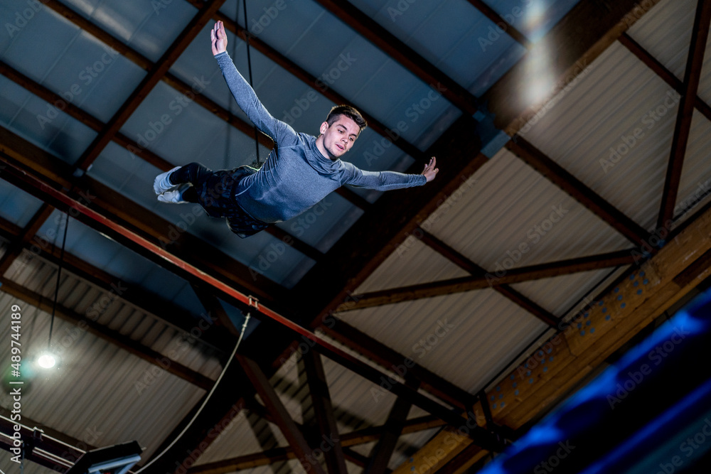 Caucasian man jumping concentrated in trampoline inside the sport ...