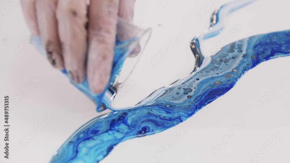 Artist pours mix of deep blue epoxy resin on canvas Stock Video | Adobe ...