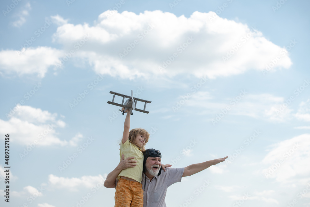 Old grandfather and young child grandson having fun with plane outdoor ...