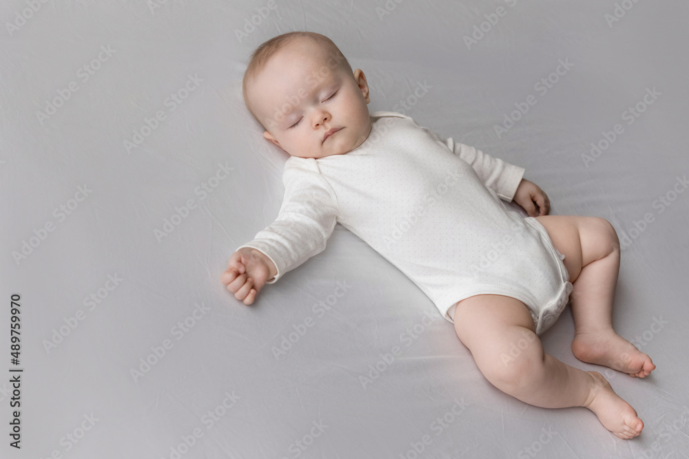 Serene peaceful sweet baby in white bodysuit sleeping on double bed ...