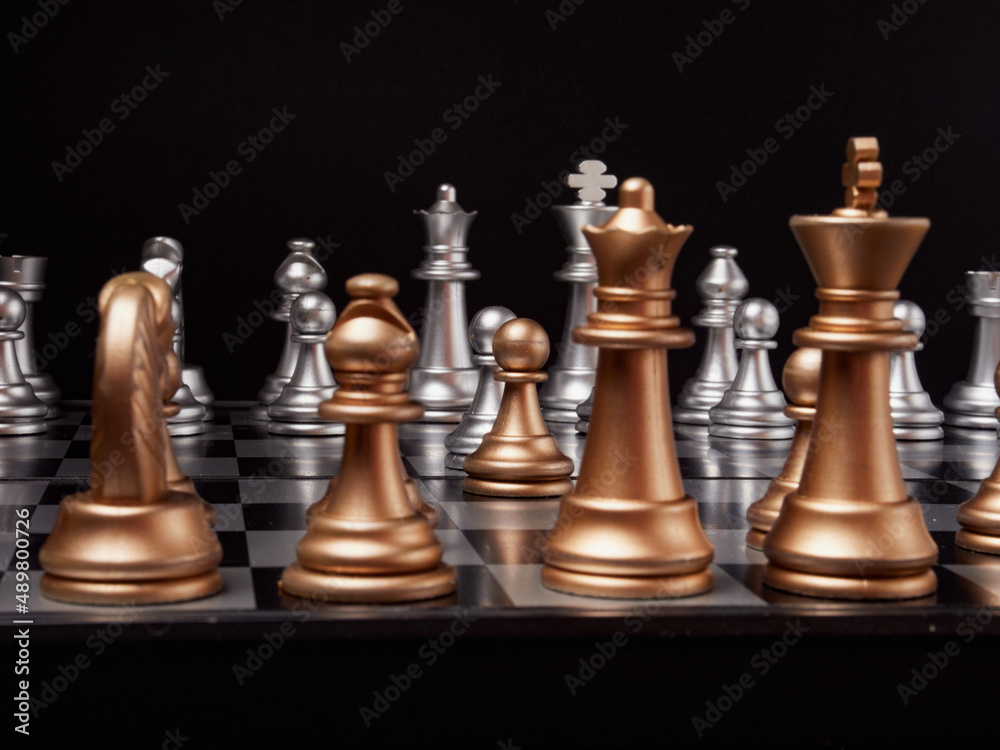 One chess piece stands against a full set of chess pieces. The concept ...
