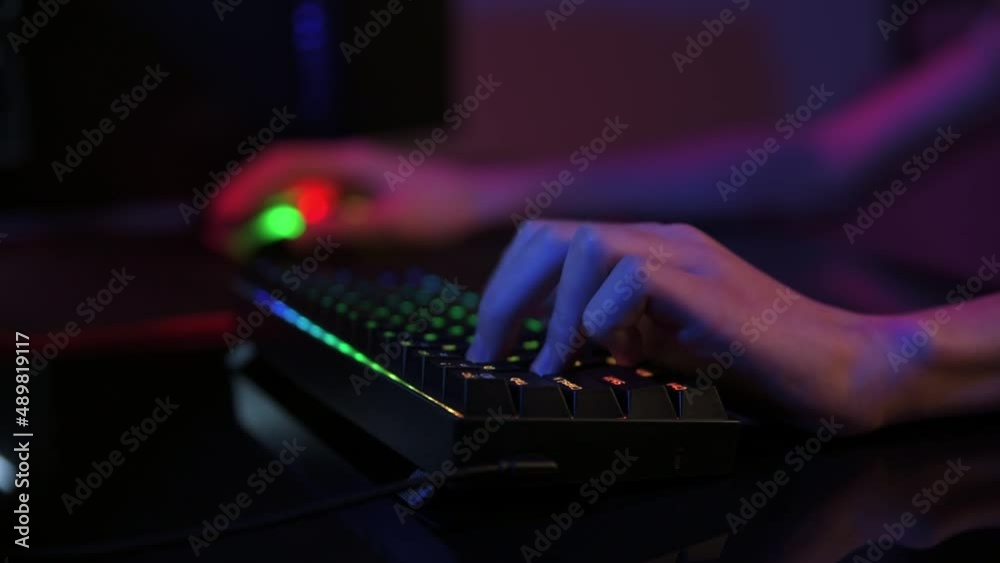 Professional gamer play computer video game in dark room, use neon ...