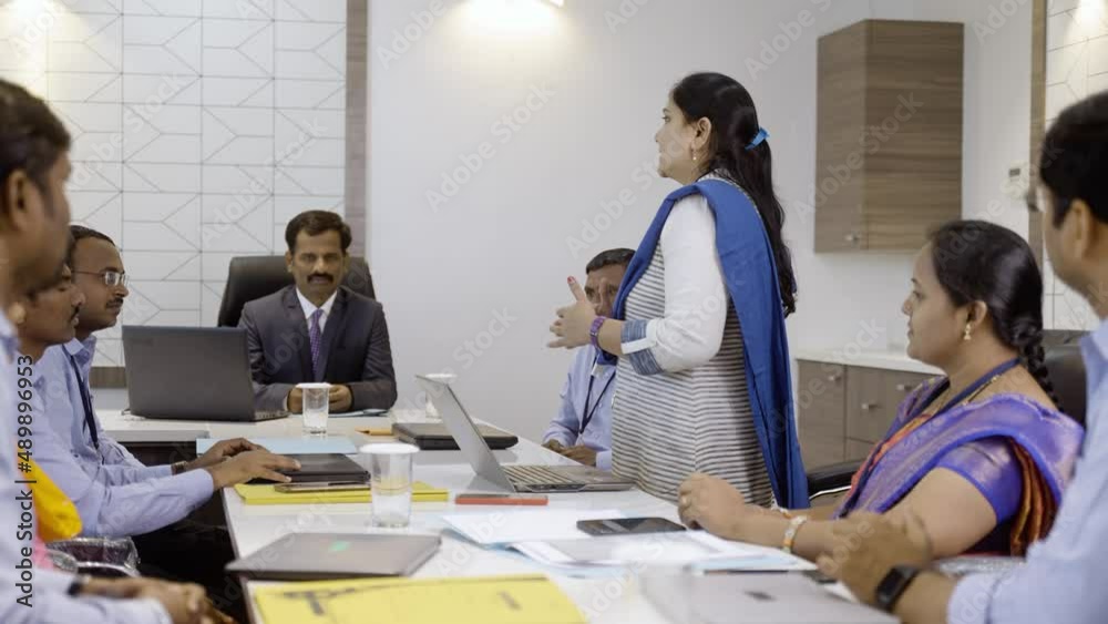 woman employee busy speaking confidently at board meeting in front of ...