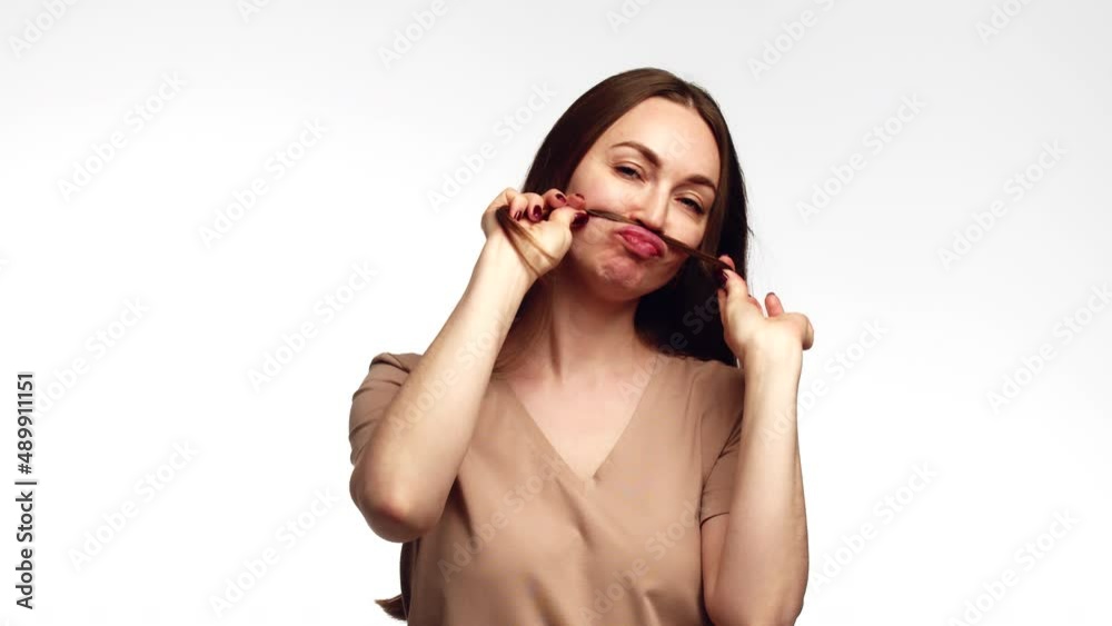 Vidéo Stock Attractive woman is fooling around with long hair making mustache out of them and ...