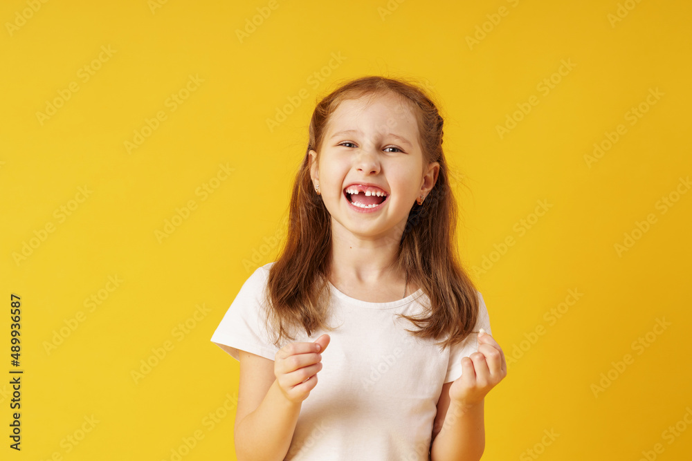 cute smiling preschool girl holds her first fallen baby tooth in her ...