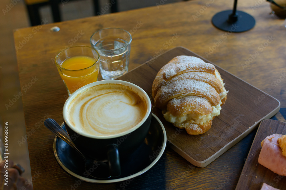 Desayuno, café con leche con medialuna con crema y jugo de naranja ...