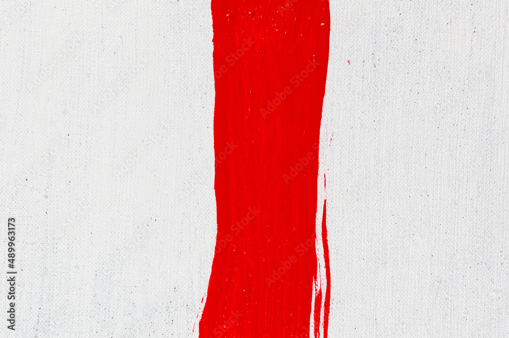 thick red acrylic paint applied in a thin, uneven stroke on a flat ...