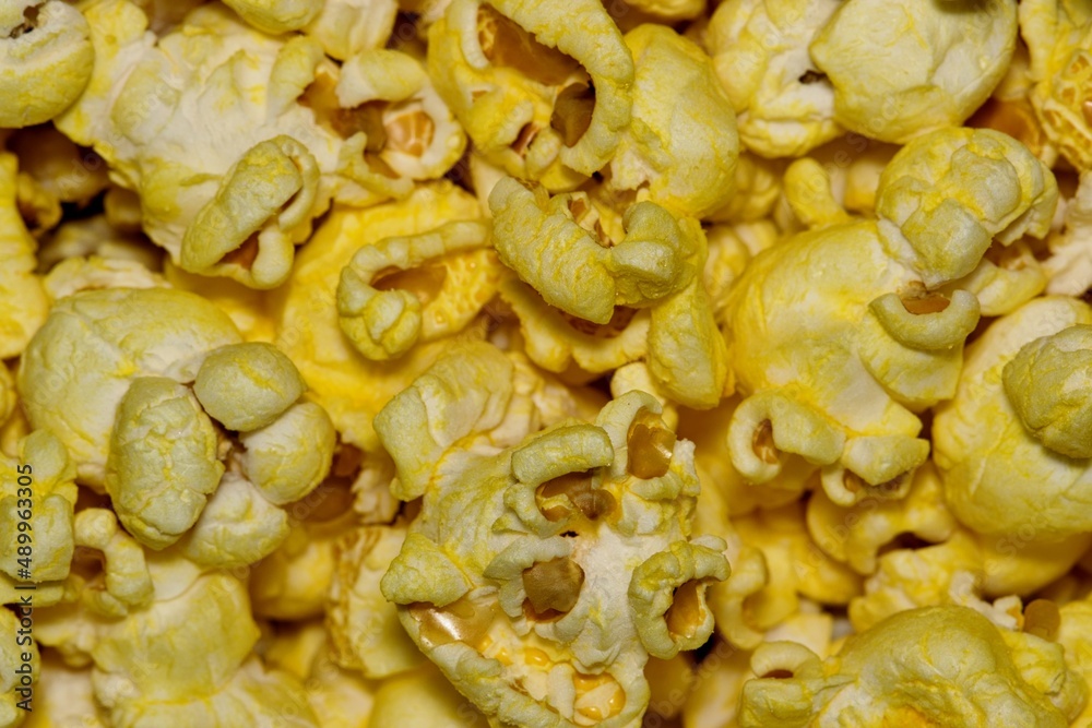 Yellow cheese flavored popcorn kernels up close with details and ...