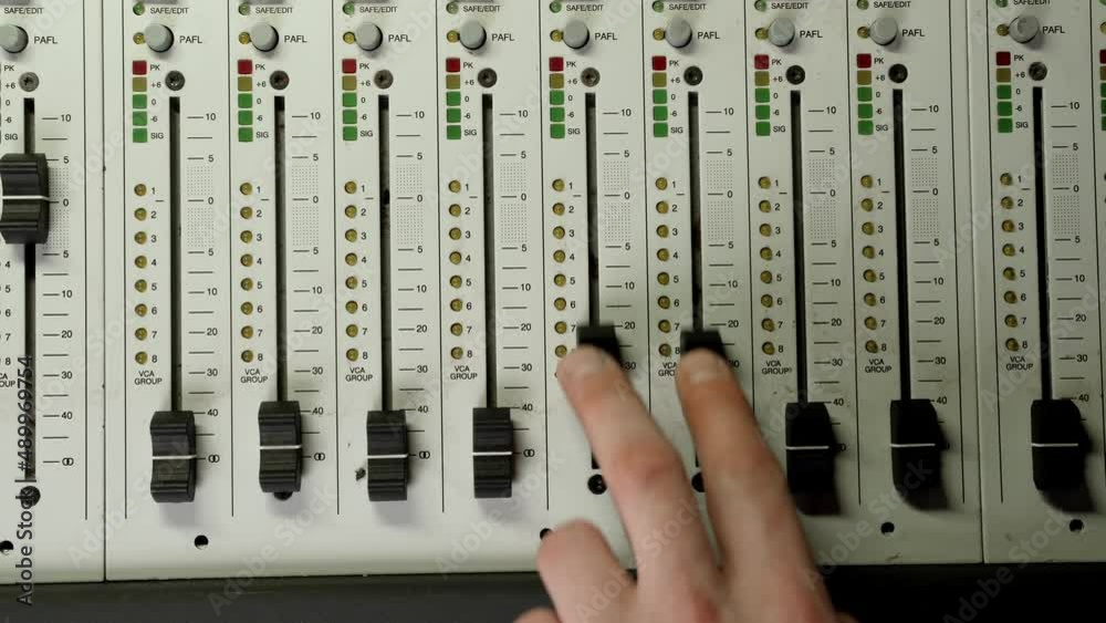 Music Mixer desk table in recording studio. Musician tunes electronic ...