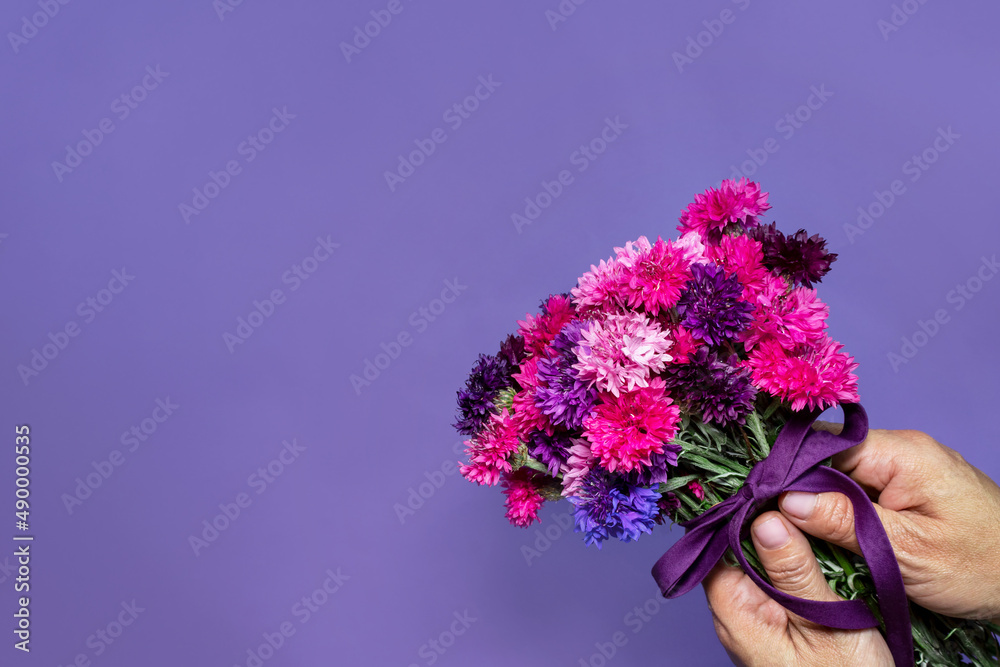 Manos de mujer entregando ramo de flores de colores rosas, moradas ...
