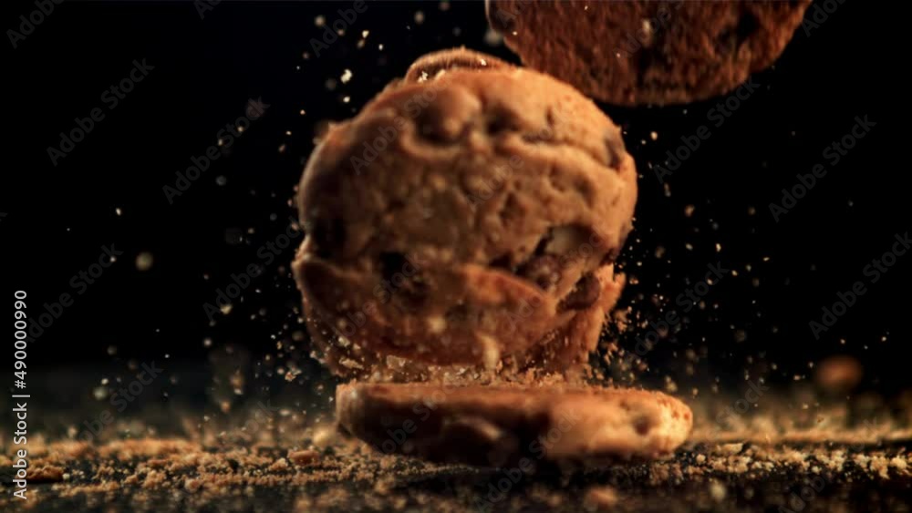 Cookies with pieces of chocolate fall on the table and crumble. On a ...