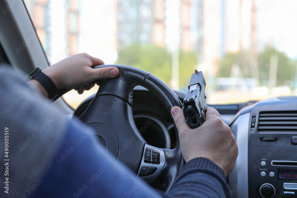 Driver with a pistol in a car. Chase. Stock Photo | Adobe Stock