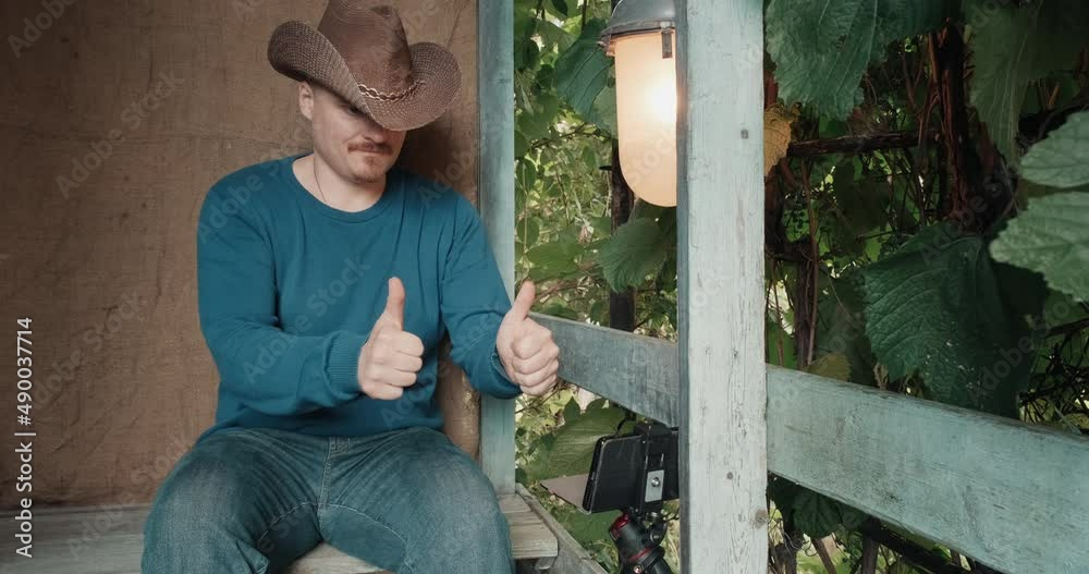 Cowboy man communicates online using his phone while sitting on the ...