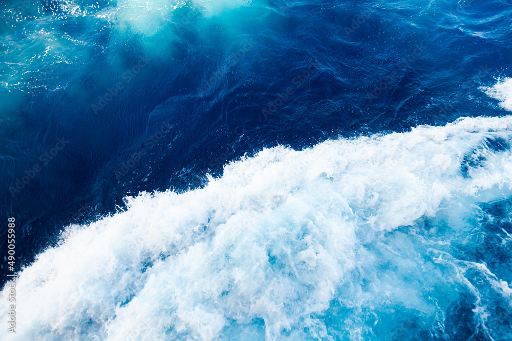 Rolling waves in the ocean. Blue water background with white foam ...