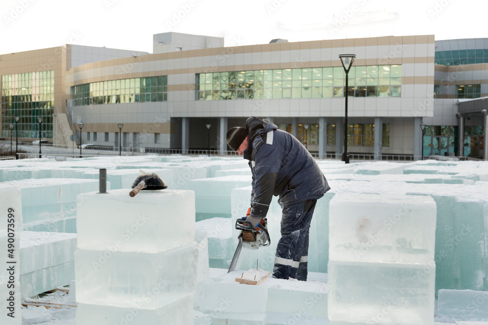 Worker cuts a lump of ice with a chainsaw Stock Photo | Adobe Stock