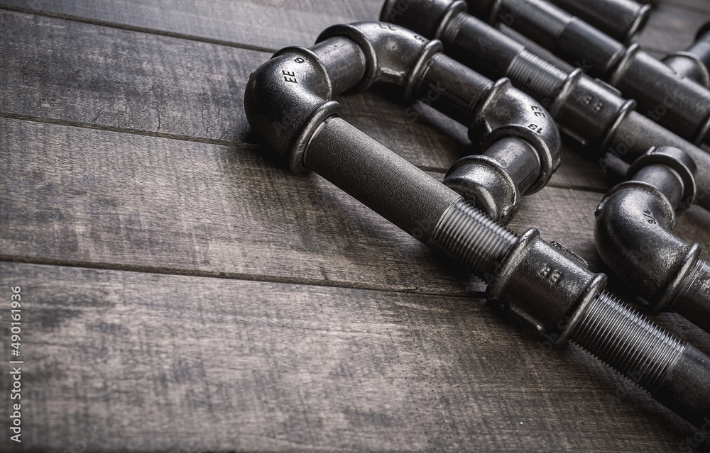 Cast iron pipes and fittings of different shape and forms, laying on a ...