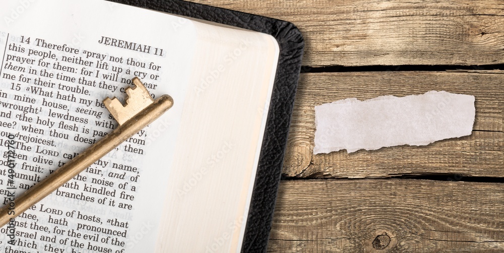 God Bible with an old, vintage key on a wooden table. Christian ...