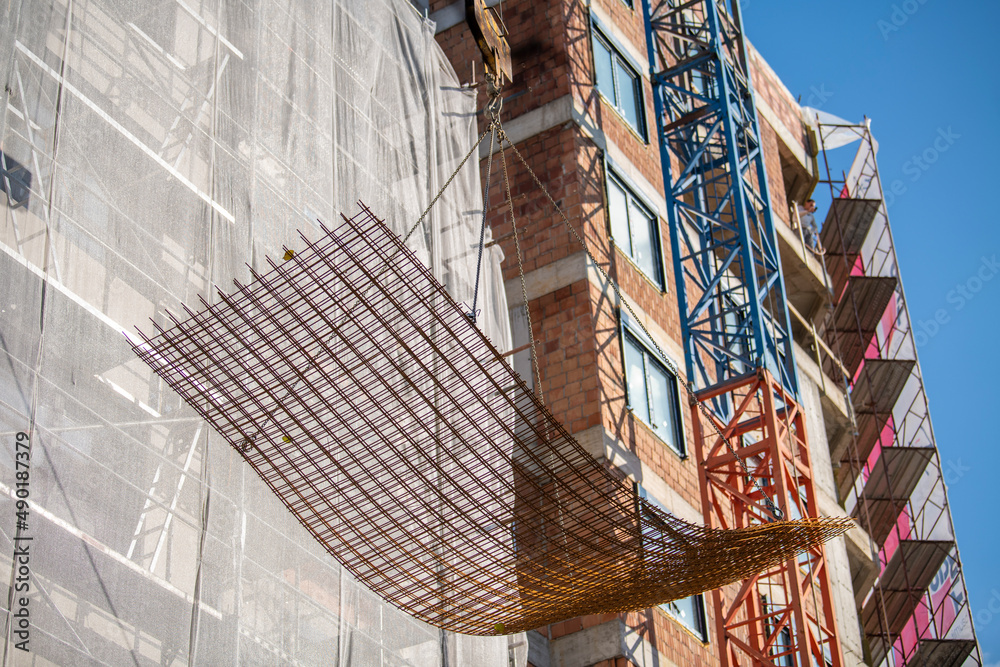 Rebar or armature for concrete pour hanging from the crane in front of ...