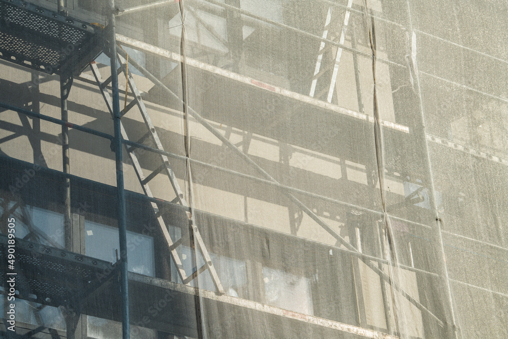 Net wrap or protective mesh covering scaffolding of multi-story ...