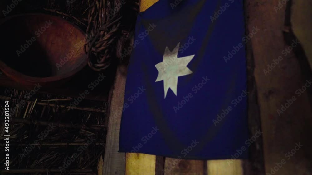 Handheld of a blue Guñelve Mapuche flag hanging from the interior wall ...