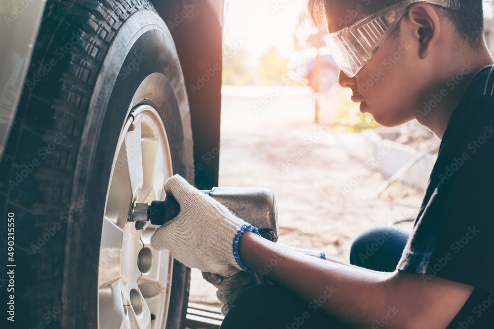 serviceman removing bolt from a wheel using pneumatic gun, tire ...