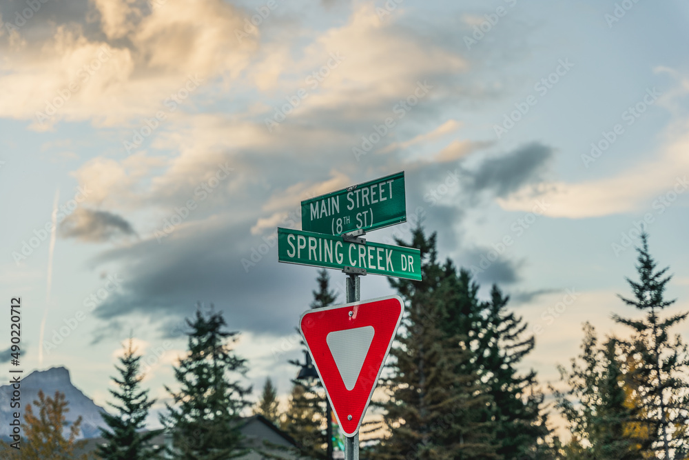 Beautiful wallpaper of road signs with blue cloudy sky and fir trees in ...