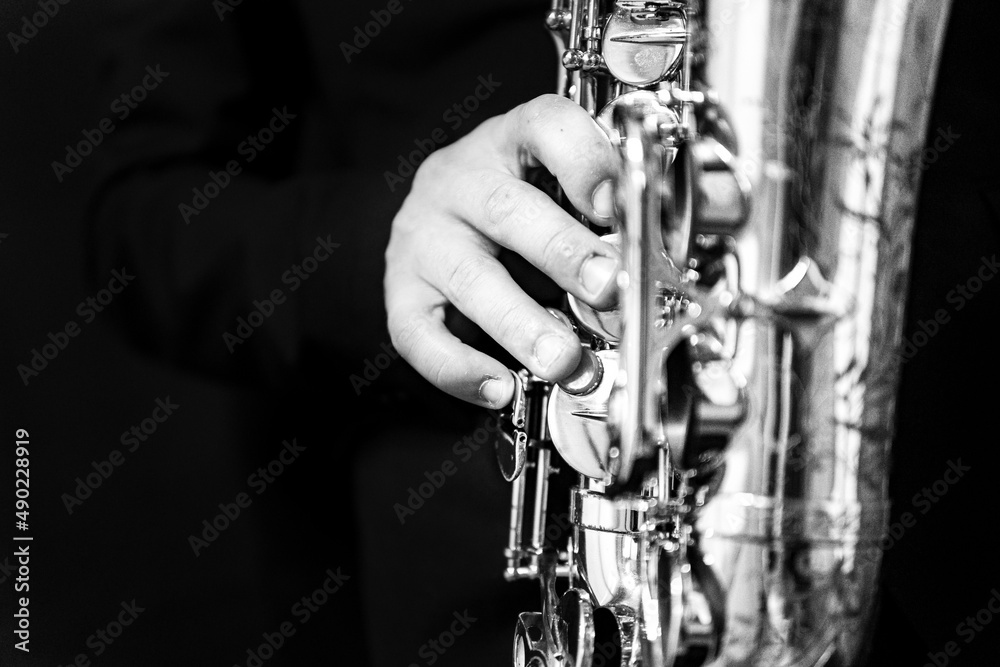 Grayscale of a man's hand playing a saxophone Stock Photo | Adobe Stock