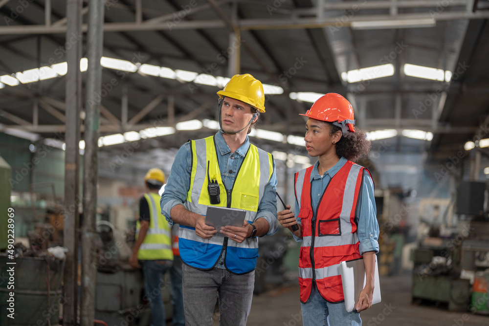 Professional engineering workers walk and check in warehouse factory ...