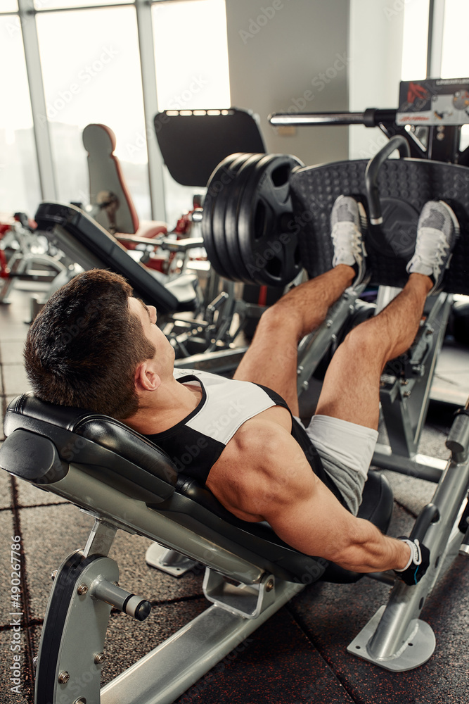 Training legs in the simulator, the athlete works with his legs on the ...